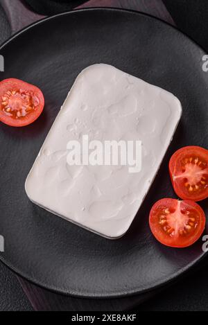 Tasty feta cheese, vegetables and spices on board Stock Photo - Alamy