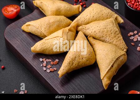 Delicious pancakes triangular shape with meat, salt and spices Stock ...