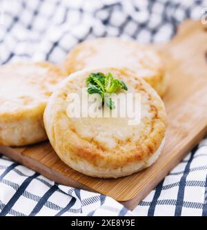 Board with tasty cottage cheese pancakes and sauce on table, closeup ...