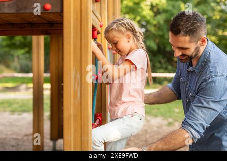 Father Encouraging Daughter to Climb Rope Ladder on Playground Stock ...