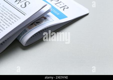Different newspapers on grey background Stock Photo - Alamy