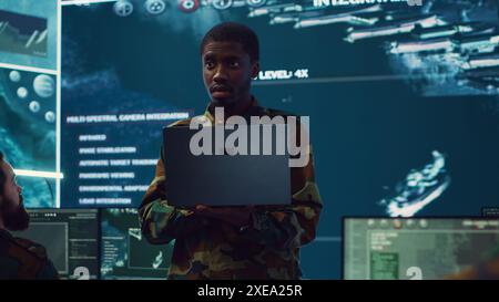 Infantry unit leader examines big data on a screen in military ...