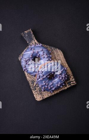 Delicious sweet donut of purple color in glaze and with lilac balls ...