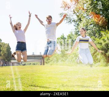 Three joyful teens jump on a lawn Stock Photo - Alamy