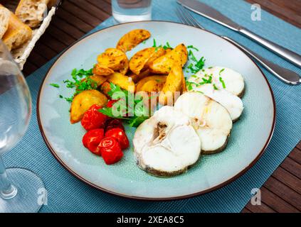 Hake fish with parsley, pickled tomatoes and potatoes Stock Photo - Alamy