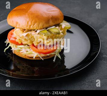 Homemade burger with fish, cheese and salad leaves served potato and ...