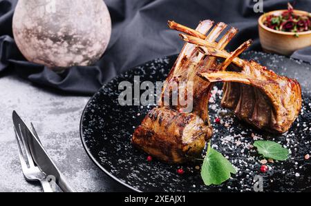 Grilled lamb rib chop steaks, medium rare with french fries on plate ...