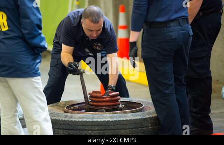 NTSB highway investigator Dave Pereira examines wheel of the DUKW ...