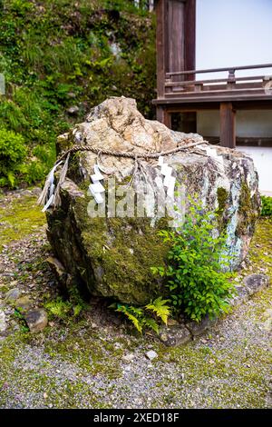 A sacred rice straw rope (shimenawa) marks the entrance to a Shinto ...