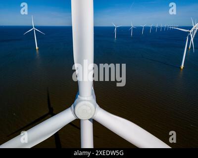 A mesmerizing aerial view of a wind farm in the ocean, with rows of ...