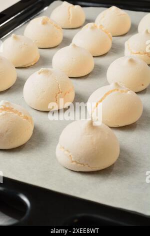 Meringues on a baking tray, on a white textured background Stock Photo ...