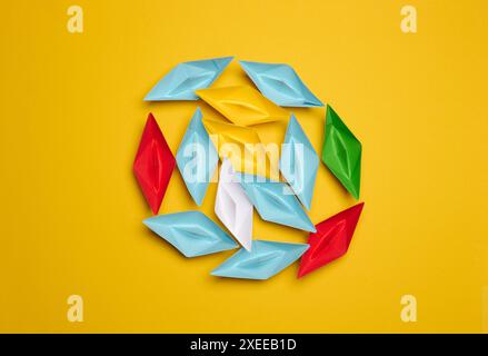 A group of colorful paper boats clustered on a yellow background Stock ...