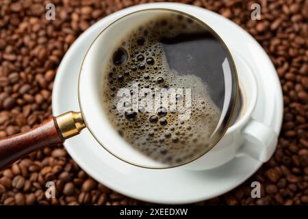 Espresso under a magnifying glass. Focus on a foam. Conceptual image on ...