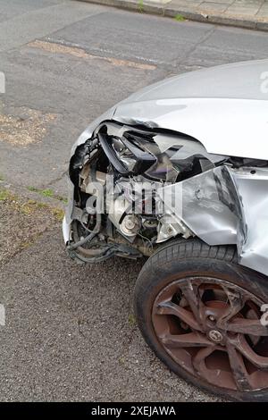 A badly damaged nearside front wing of a small salon car exposing the ...