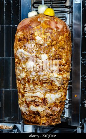 Traditional doner kebab roasted on vertical rotisserie in a street ...