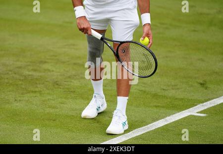 Strapping on the knee of Novak Djokovic on the practice court at the ...