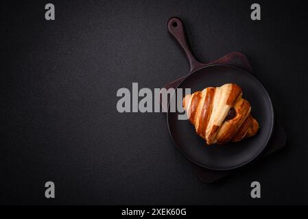 Delicious crispy sweet croissant cornet with chocolate on a dark ...