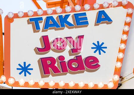 Colourful fairground ride sign saying TAKE A RIDE JOY RIDE with an ...