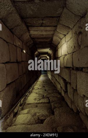 A dimly lit stone passageway leading to an ancient structure in Merida ...