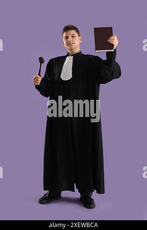 Teenage judge with gavel and law book on grey background, back view ...