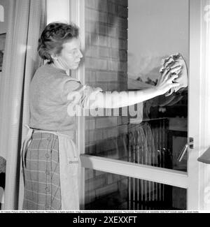Windowcleaning in the 1950s. A woman is seen preparing a rag with the ...