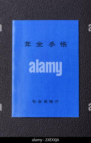 Pension book or Japanese citizen ID card on dark concrete background ...