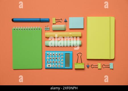 Flat lay composition with notebooks and different stationery on orange ...