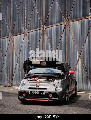 A grey silver and red Fiat Abarth 595 isolated with the bonnet open and ...