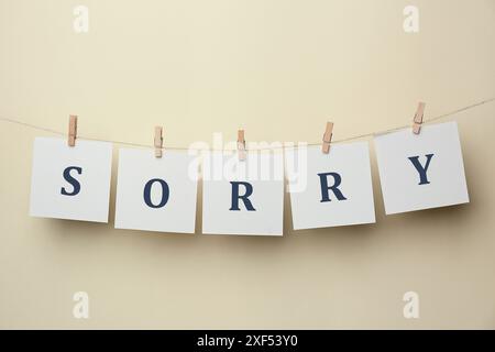 Word Sorry made of paper notes with letters hanging on rope against ...