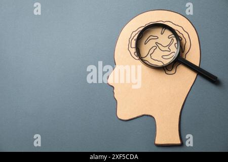 Amnesia. Human head cutout with drawing of brain and magnifying glass ...