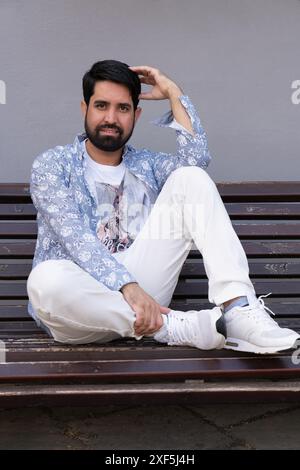 A modern, stylish Pakistani man with a dark beard and light clothes ...