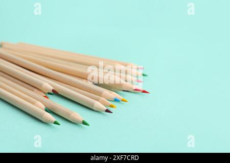 Color pencils on turquoise background, flat lay with space for text ...
