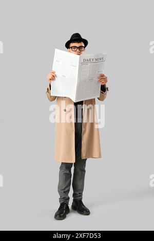 Male spy with newspaper on light background Stock Photo - Alamy