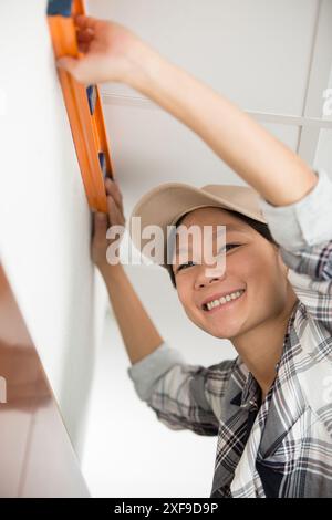 focused female worker using a spirit level Stock Photo - Alamy