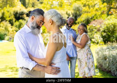 Dancing together outdoors, senior bride and groom enjoying garden party ...