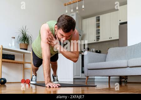 Man does arms curling exercise in plank position. Home workout Stock ...