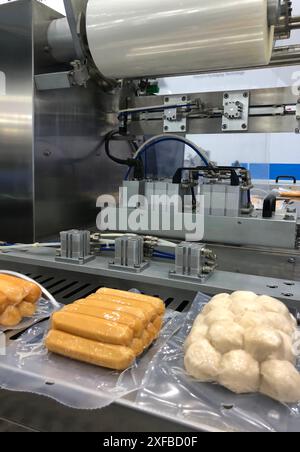 High-performance machines are wrapping processed fresh food products sausages. food production ...