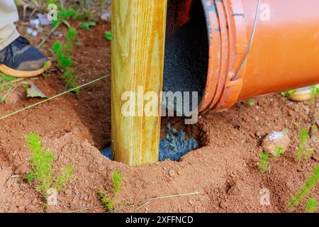 Concrete pouring of newly installed timber fencing wooden fence posts ...