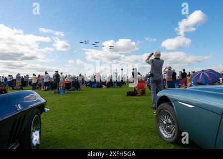 Airshow crowd watching a flypast of Second World War Spitfire planes ...