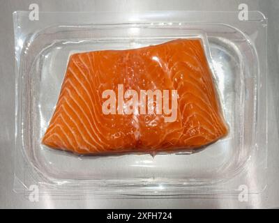 A piece of raw fish is vacuum-sealed in a clear plastic bag with a ...