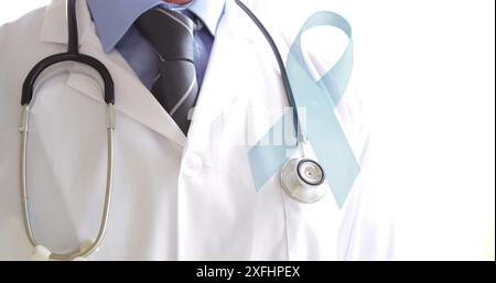 Image of blue cancer ribbons over smiling caucasian male doctor on ...
