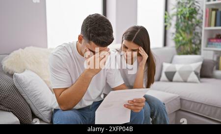 Sad couple with financial problems and troubles showing the calculator ...