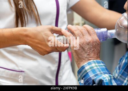 Nurse applying a medicine during inhalation to senior man suffering ...