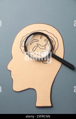 Amnesia. Human head cutout with drawing of brain and magnifying glass ...
