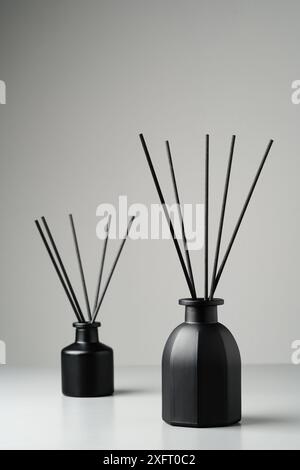 Two Black Reed Diffuser Bottles on a White Surface With Grey Background ...