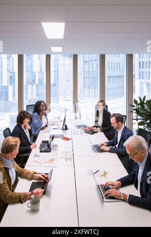 Multiracial colleagues discussing over conference table during meeting ...