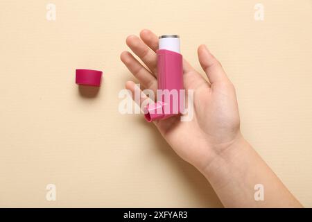 Child's hand with asthma inhaler on beige background Stock Photo - Alamy