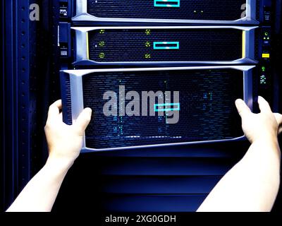Man fixing server in data center room Stock Photo - Alamy