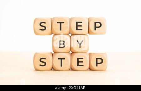 Step by Step message on wooden block shape Stock Photo - Alamy