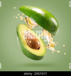 avocado with oil splash on a light green background Stock Photo - Alamy
